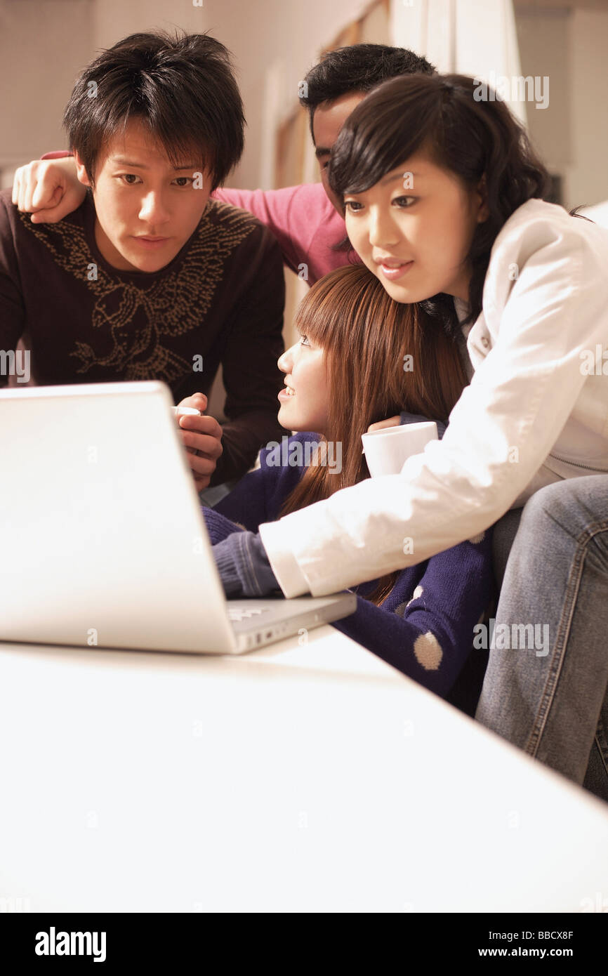 Friends using computer at home Stock Photo - Alamy