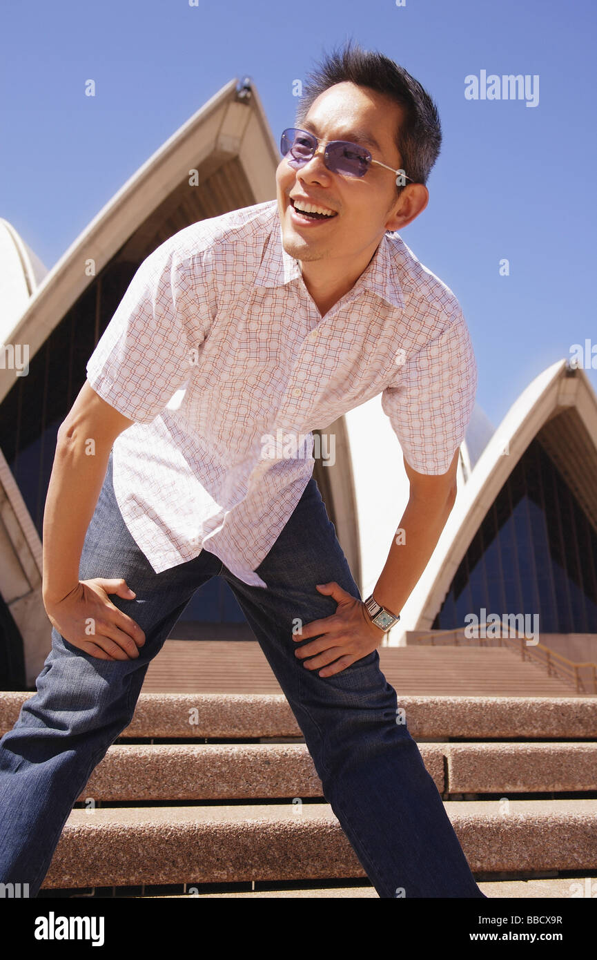 Young man leaning down. hands on legs Stock Photo - Alamy