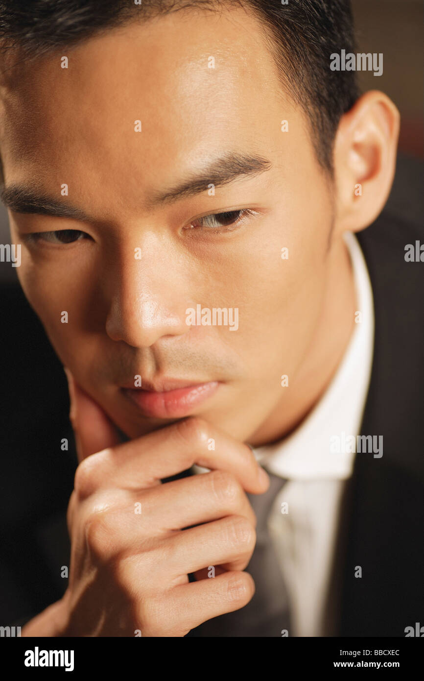 Man dressed in suit, hand on chin, portrait Stock Photo - Alamy