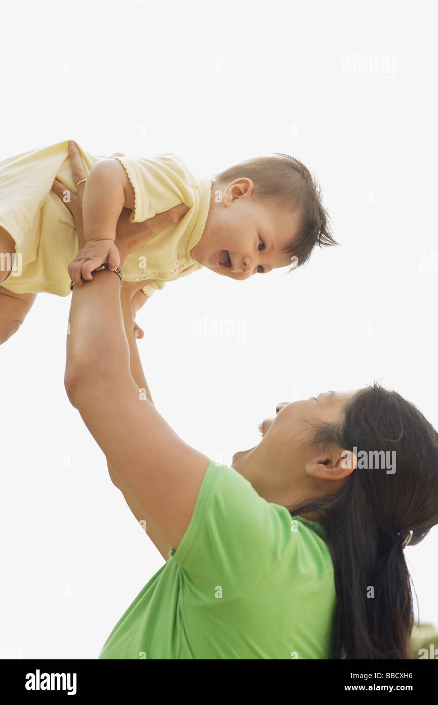 Mother lifting baby girl Stock Photo - Alamy