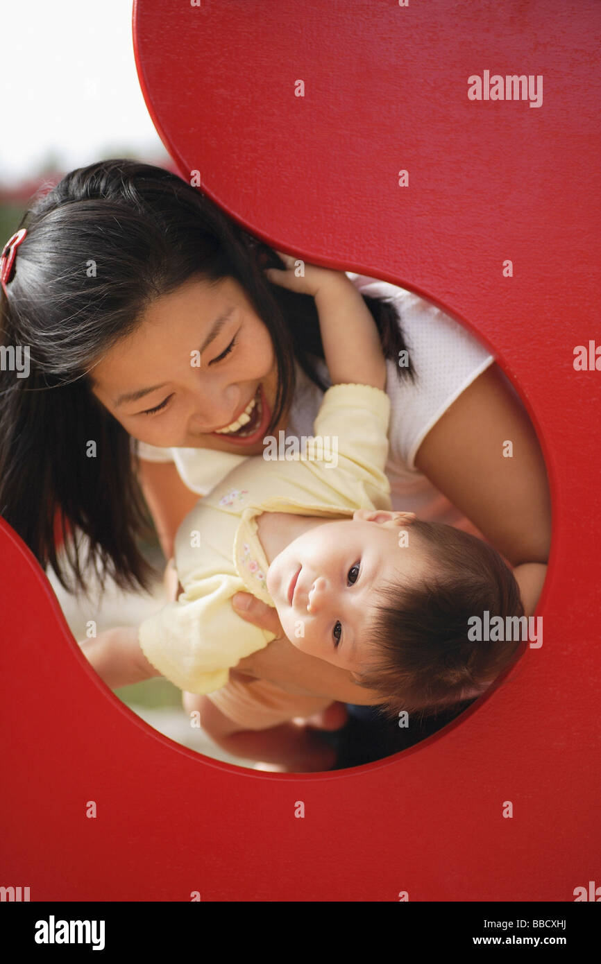 Mother carrying baby girl in playground Stock Photo - Alamy Mother carrying baby girl in playground Stock Photo - Alamy