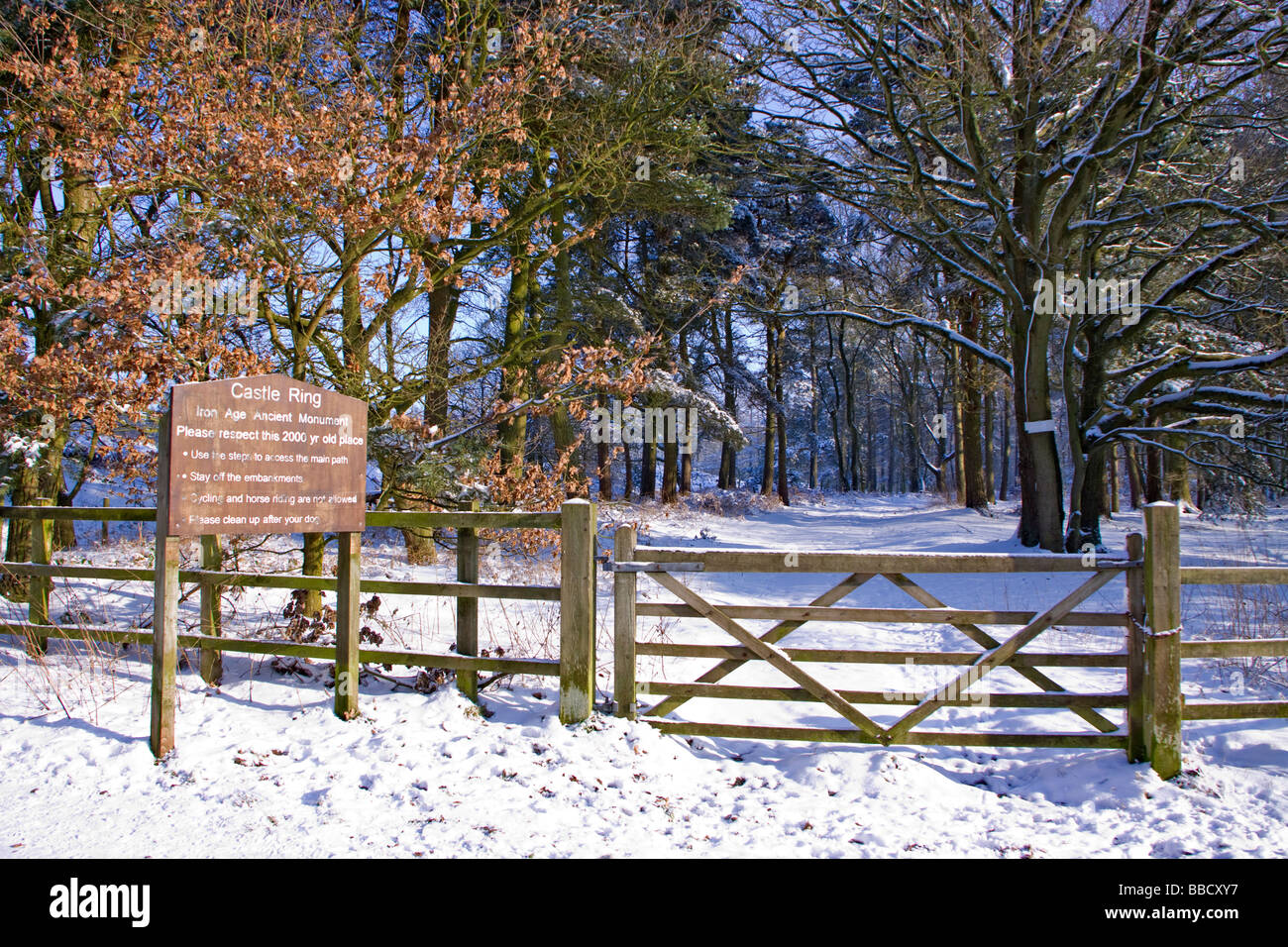 Five barred gate car park at Castle Ring snow covered trees in winter ...