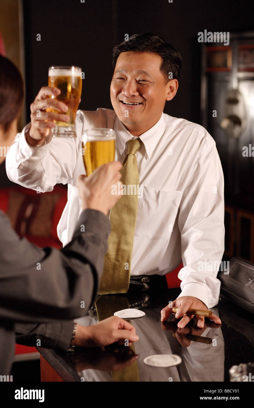 Two men raising beer glasses Stock Photo - Alamy