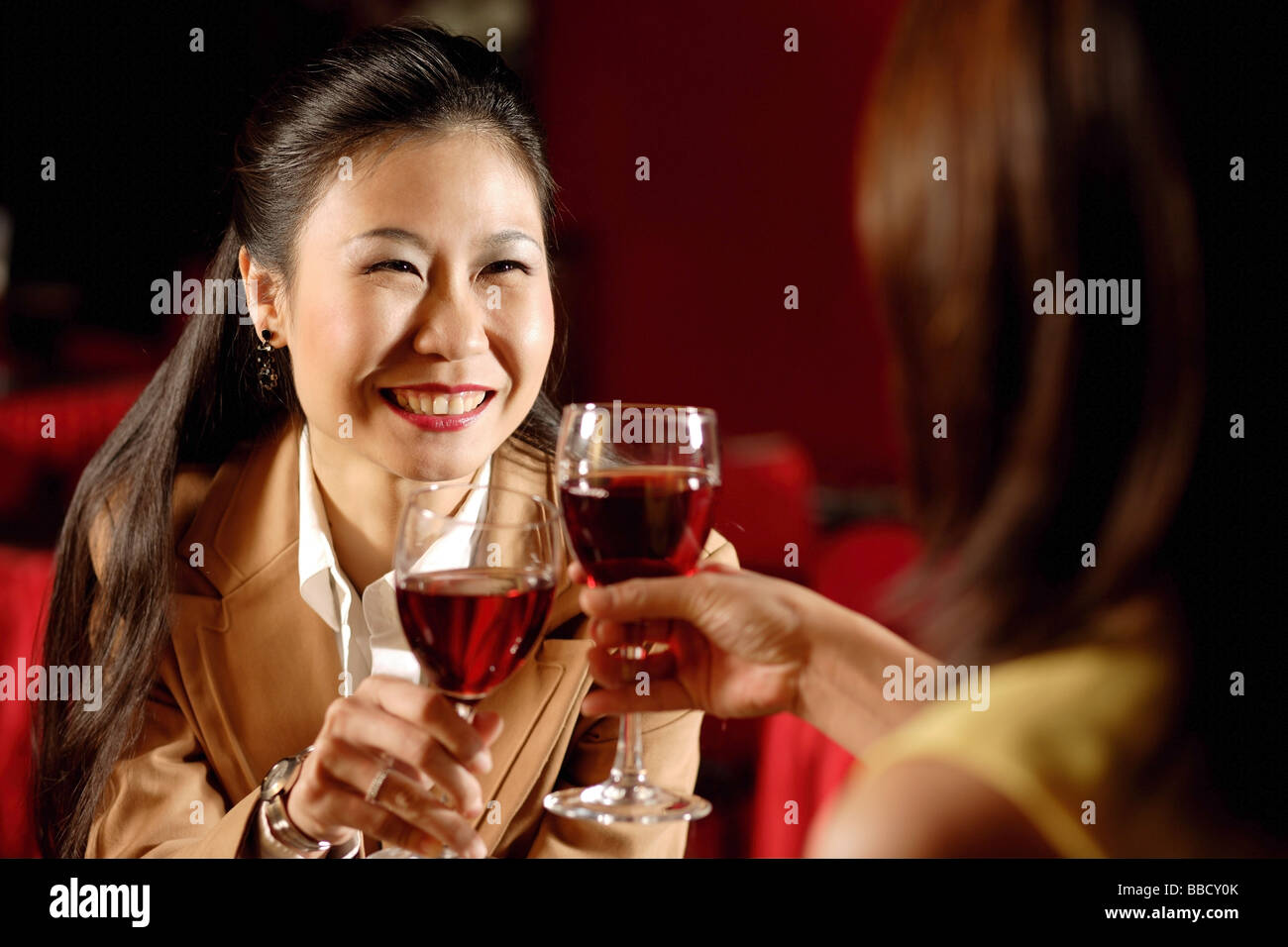 Two women toasting with wine glasses Stock Photo - Alamy