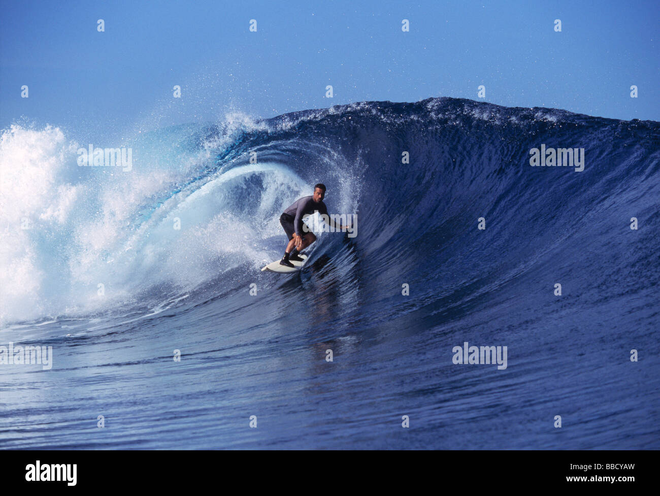 A surfer catches a perfect wave at Cloudbreak near the Fuji Island of ...