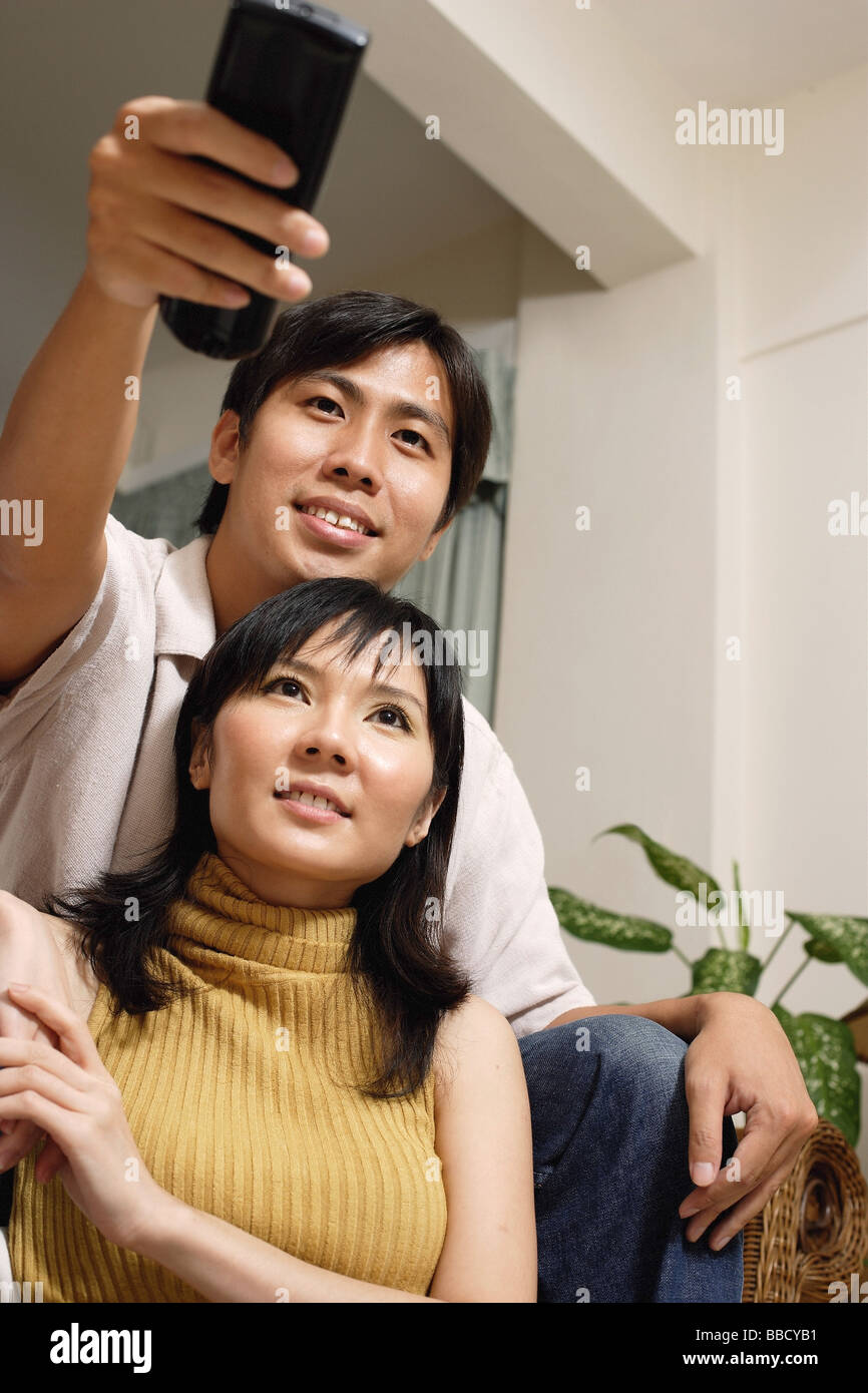 Couple at home, man holding remote control Stock Photo - Alamy