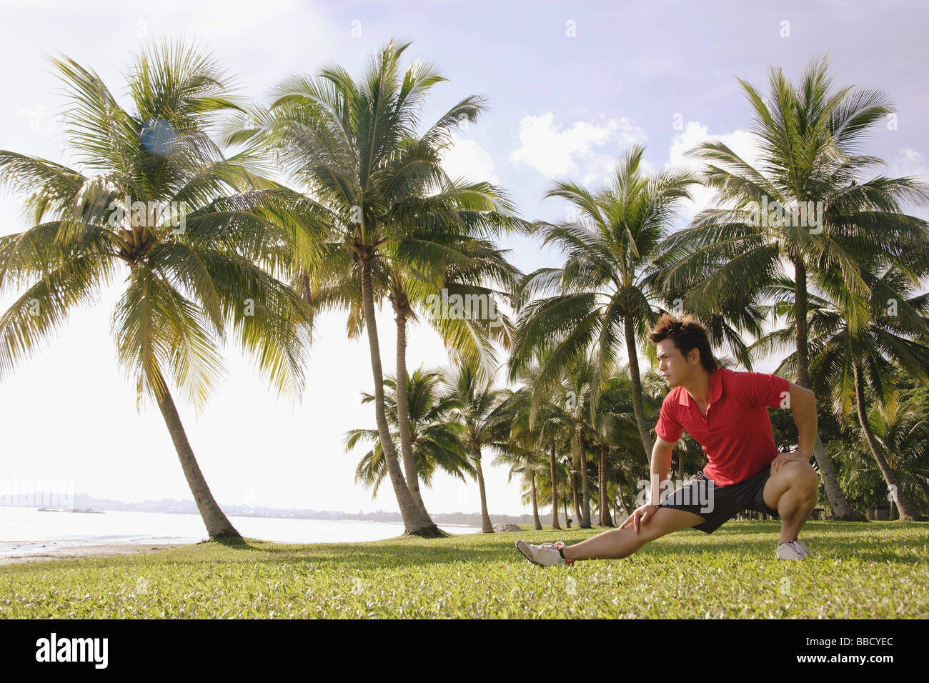 Man doing stretching exercises in park, hand on knee Stock Photo - Alamy