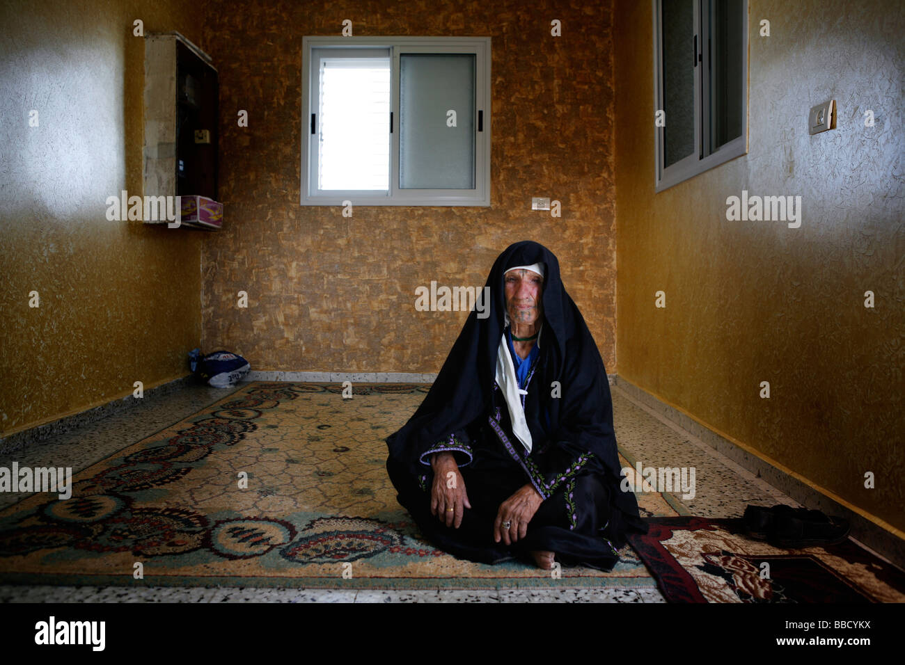 An elderly Bedouin woman sits in the living room of a house in the ...
