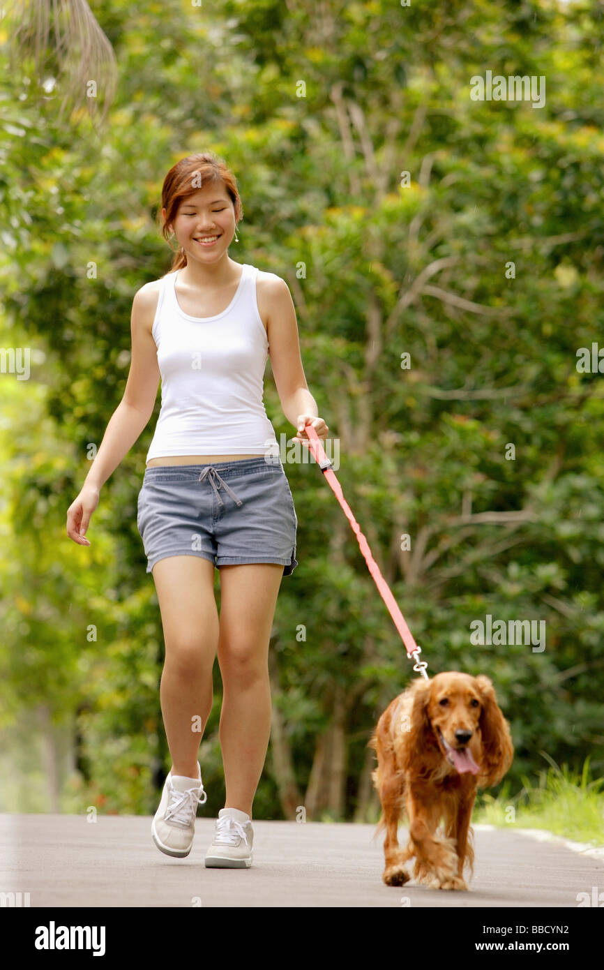 Young woman walking with her dog Stock Photo - Alamy