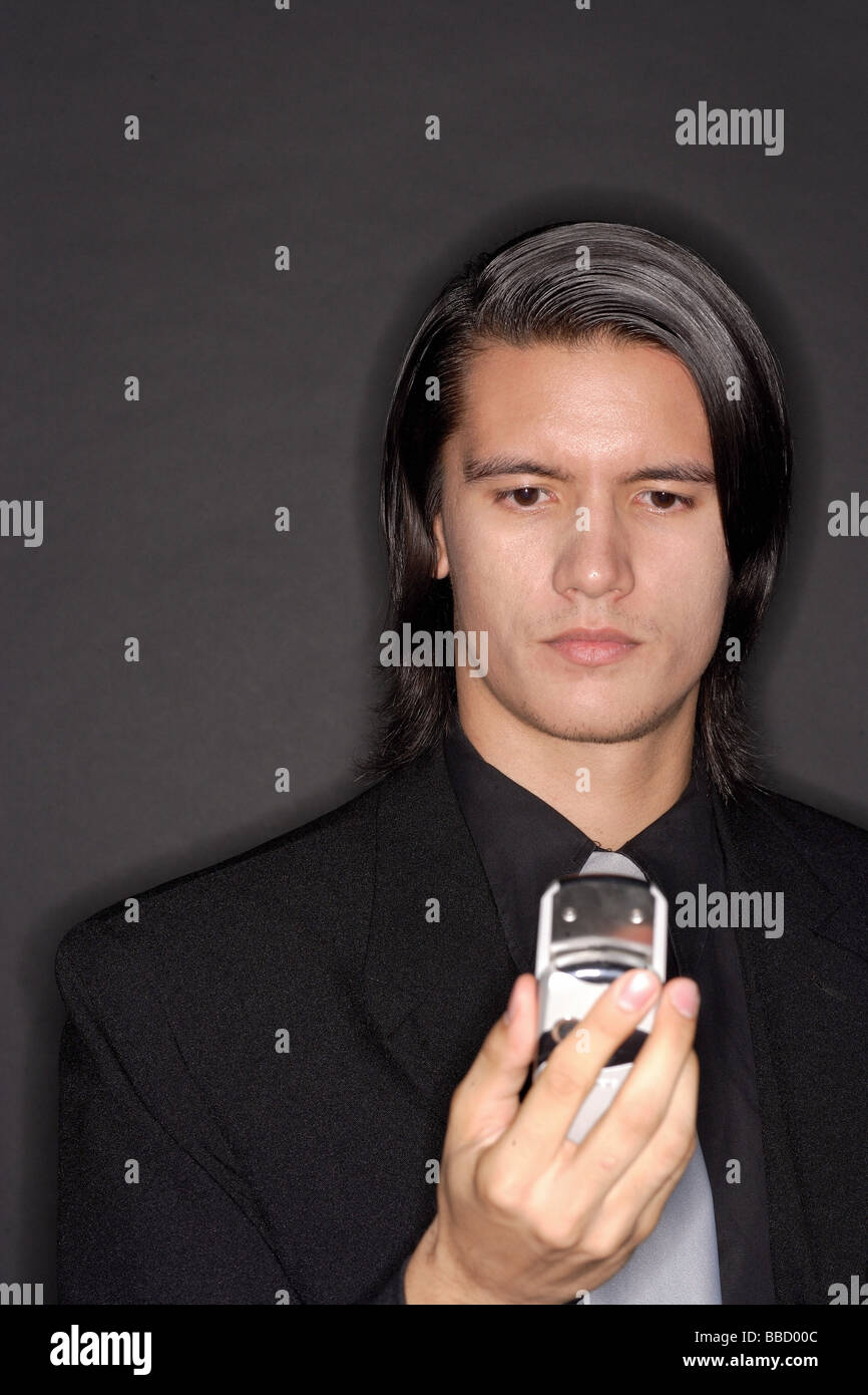 Executive holding mobile phone, portrait Stock Photo - Alamy