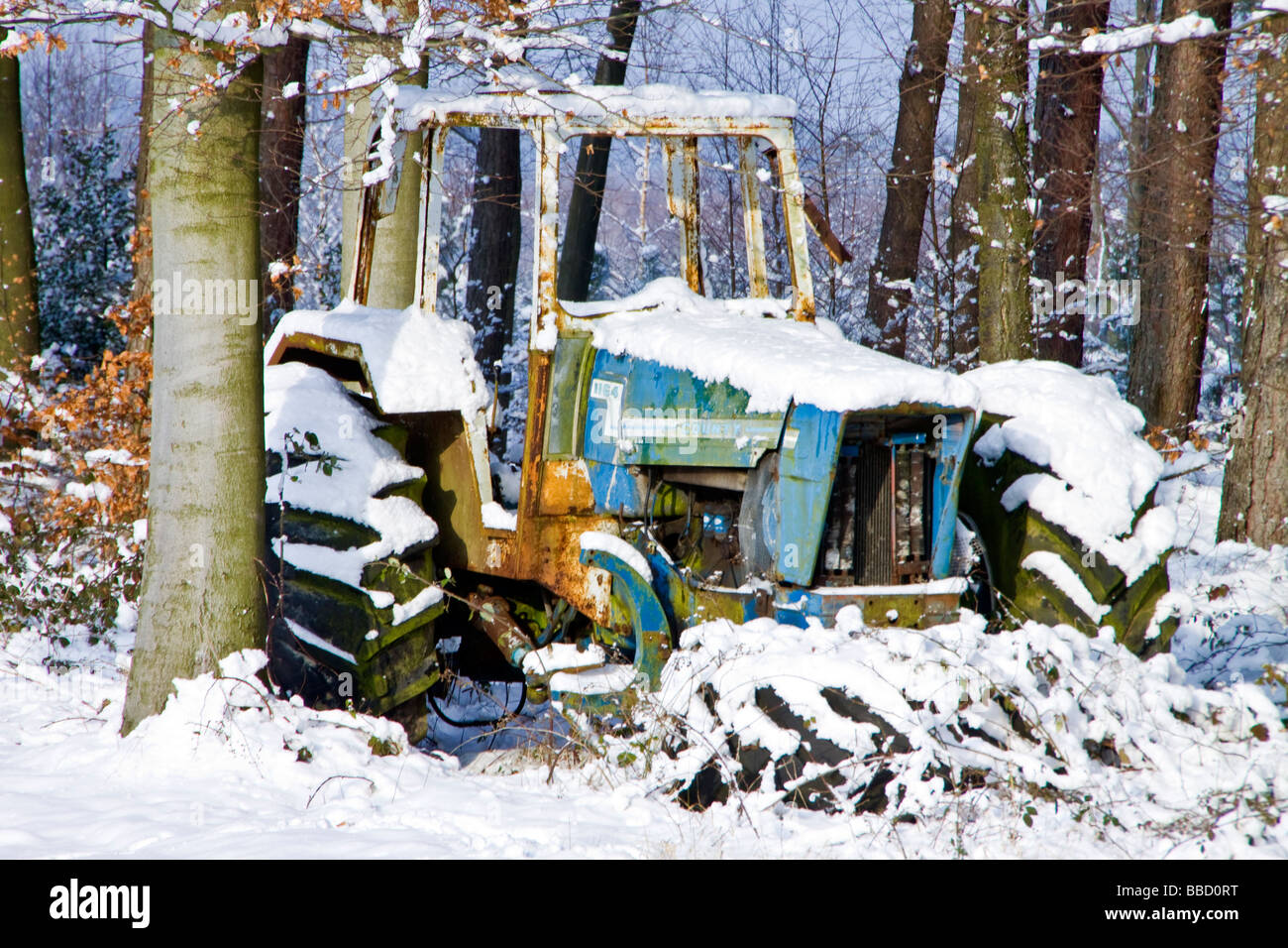 Rusty old tractor in woodland covered in snow Stock Photo - Alamy