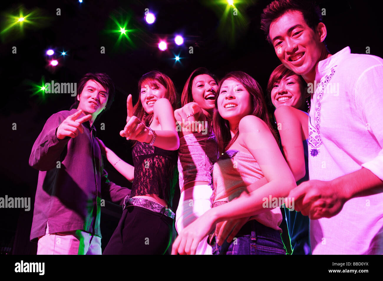 Young adults at night club, dancing in a row Stock Photo - Alamy