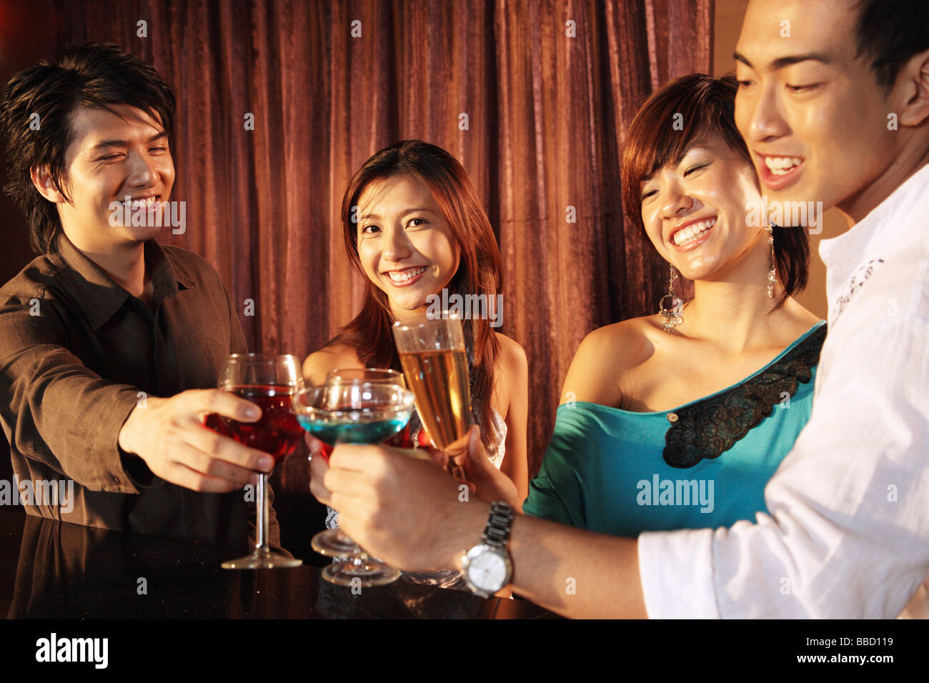 Couples toasting, woman looking at camera Stock Photo - Alamy
