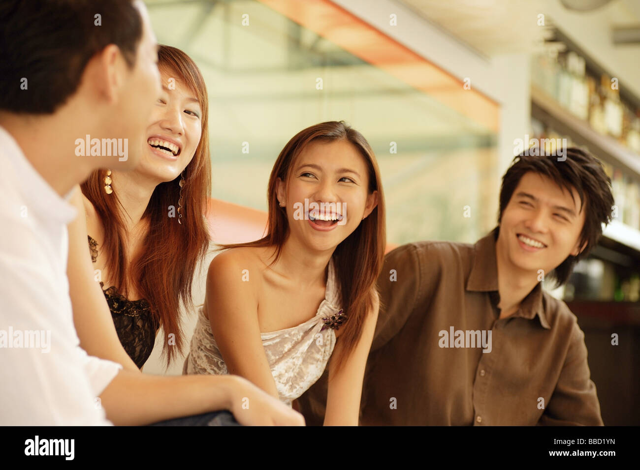 Young adults sitting together, smiling Stock Photo - Alamy