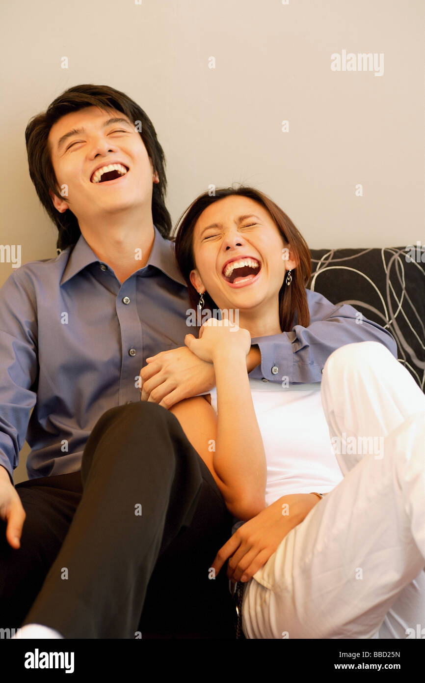 Man with arm around woman, laughing Stock Photo - Alamy