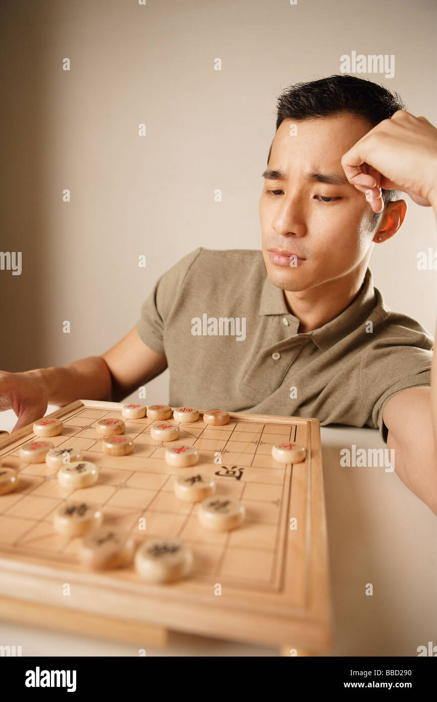 Man playing Chinese chess, hand on head Stock Photo - Alamy