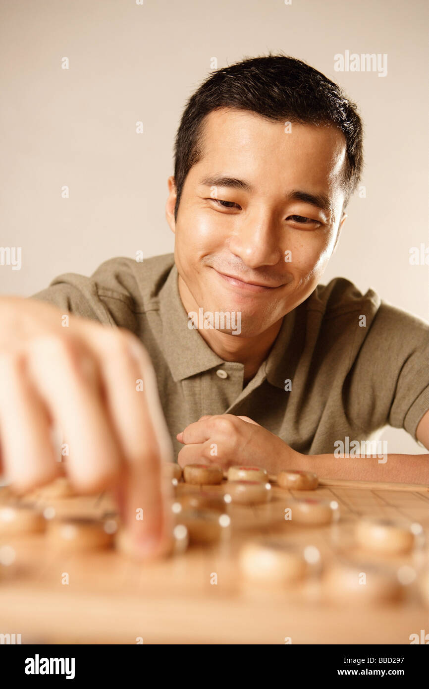 Man playing Chinese chess, smiling Stock Photo - Alamy