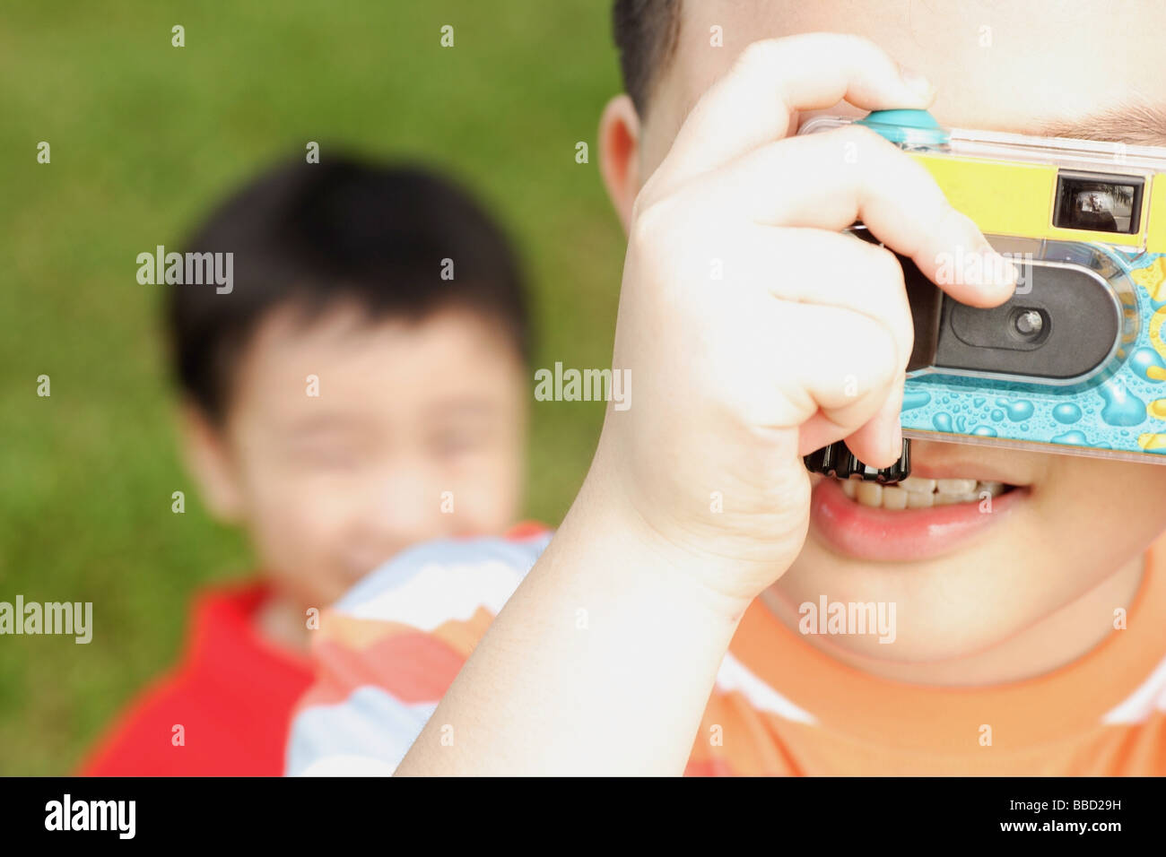Young boy looking through camera Stock Photo - Alamy