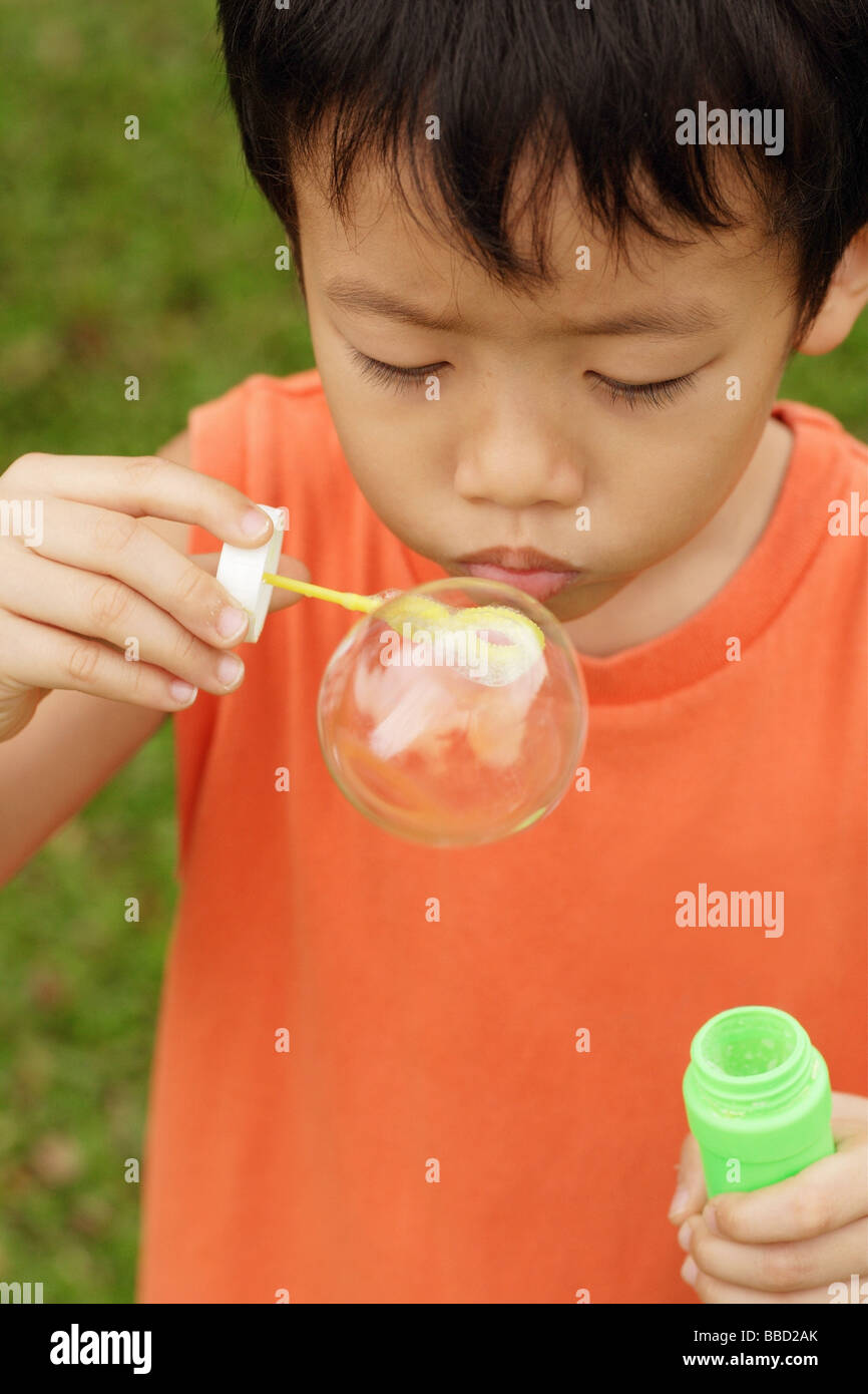 Young boy with bubble wand, blowing bubbles Stock Photo - Alamy