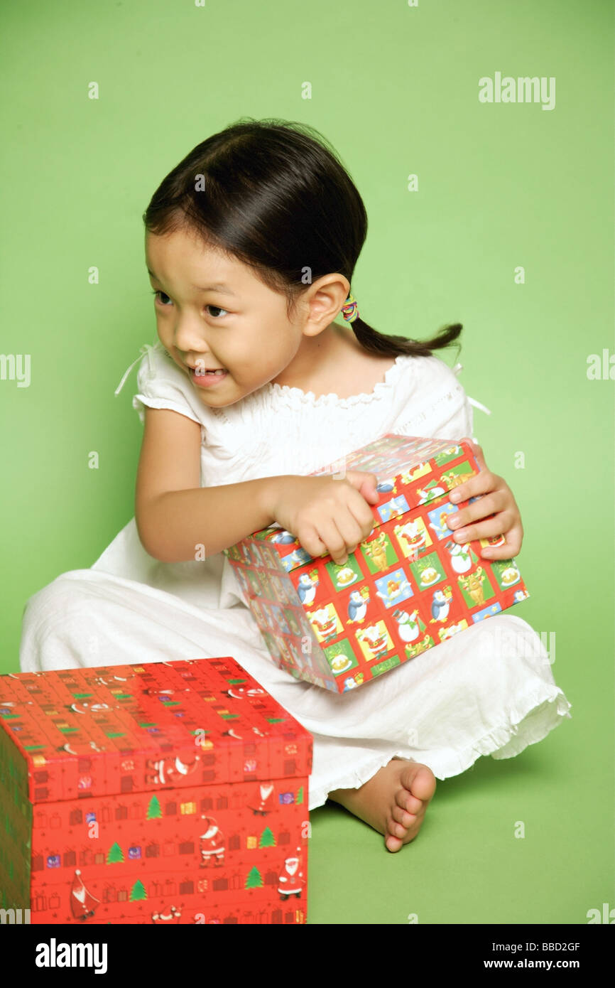 Young girl holding gift wrapped box Stock Photo - Alamy