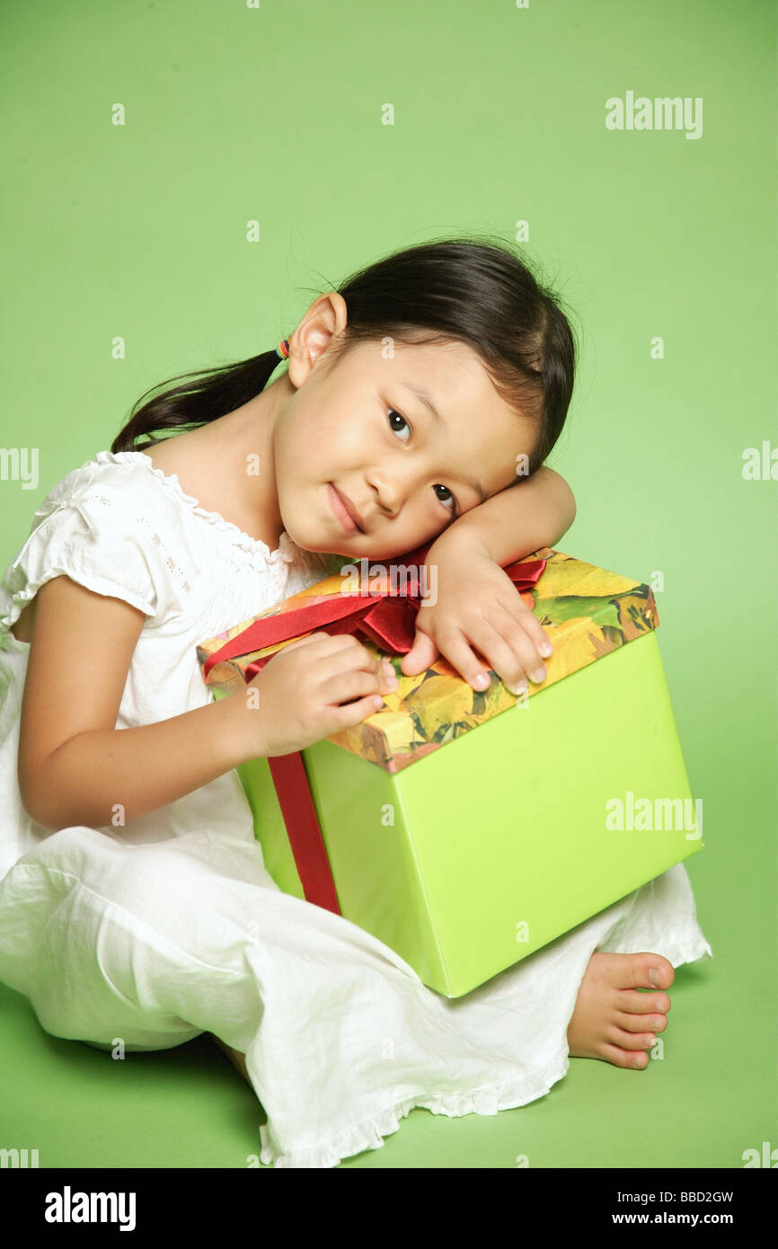 Young girl hugging gift wrapped box Stock Photo - Alamy