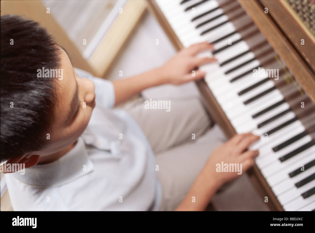 Boy sitting at piano, high angle view Stock Photo - Alamy