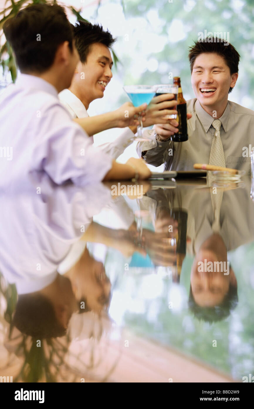 Young men raising drinks for a toast Stock Photo - Alamy