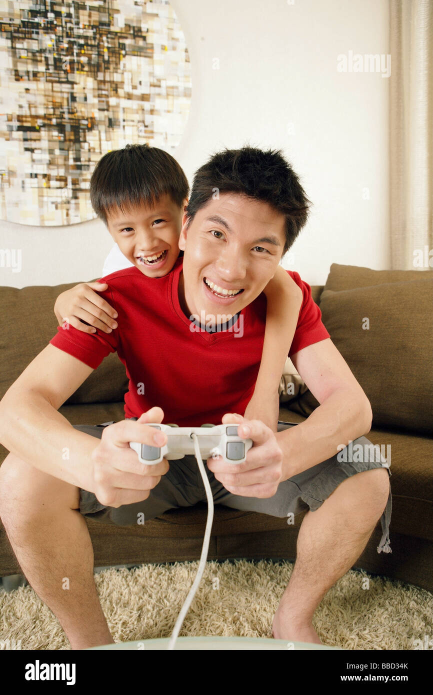 Father and son at home, father holding game controller Stock Photo - Alamy