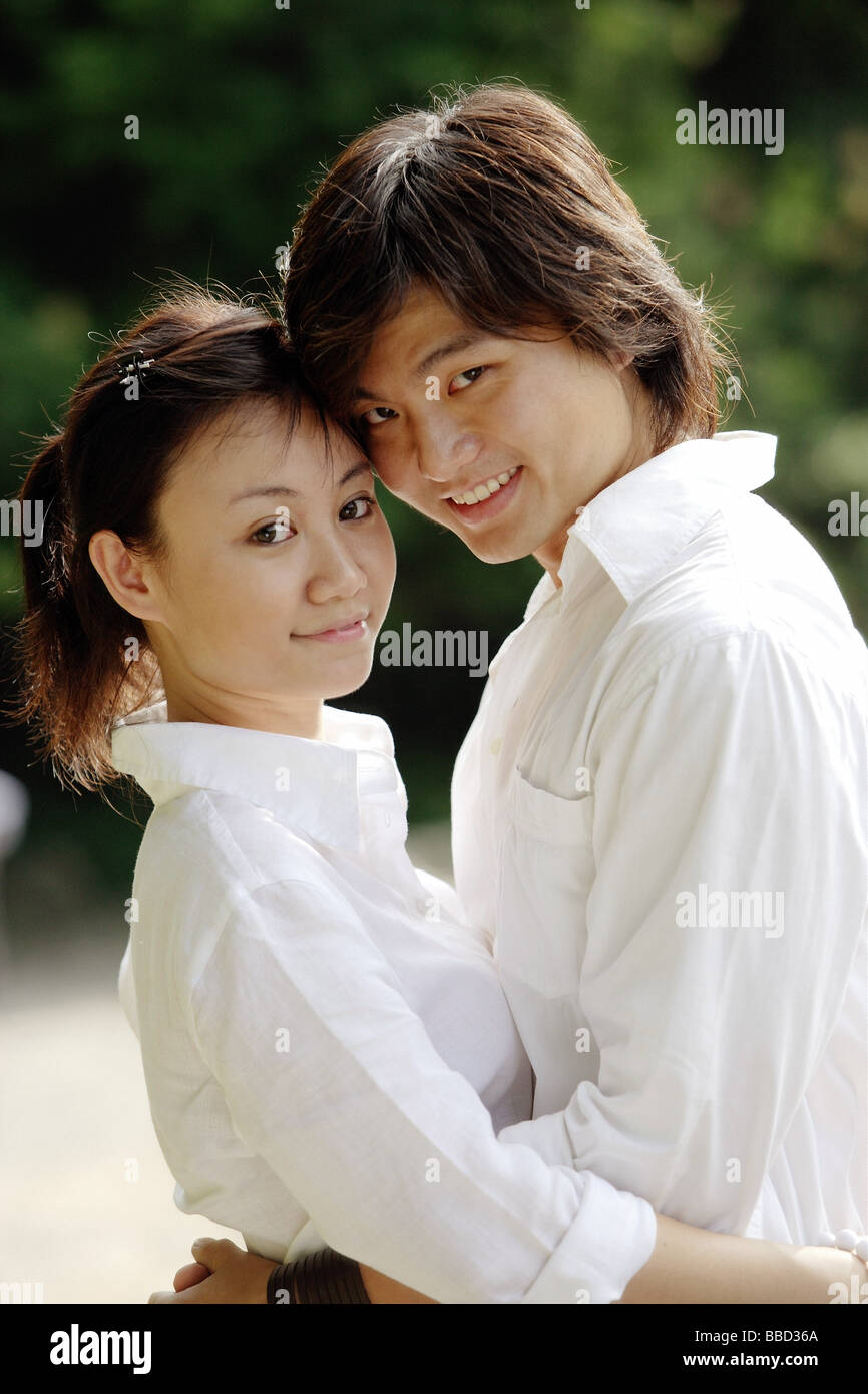 Couple hugging, looking at camera Stock Photo - Alamy
