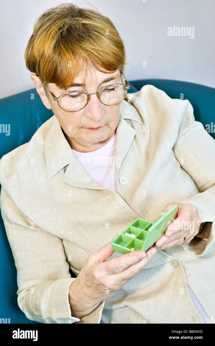 Elderly woman holding pill box with medication Stock Photo - Alamy