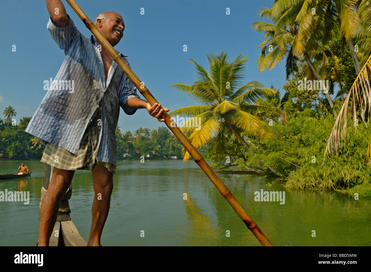 Indian boatman with a punt pole on a boat in the backwaters. Kerala ...
