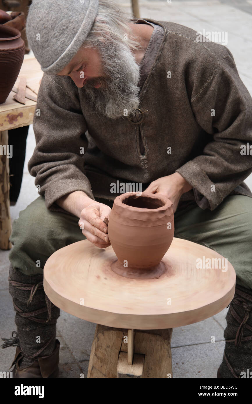 An artist making a clay pot in the traditional method on a potters ...