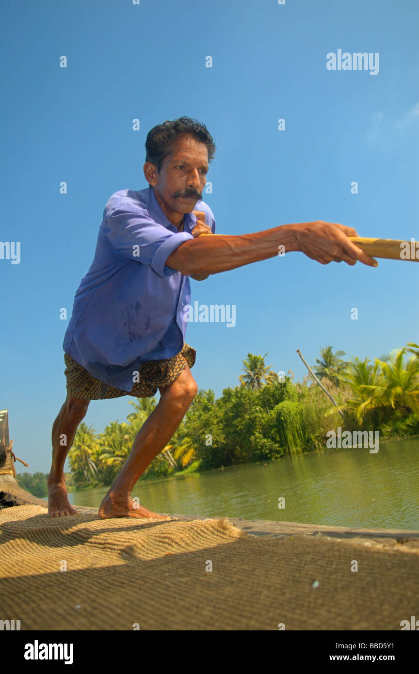 Indian boatman with a punt pole on a boat in the backwaters. Kerala ...