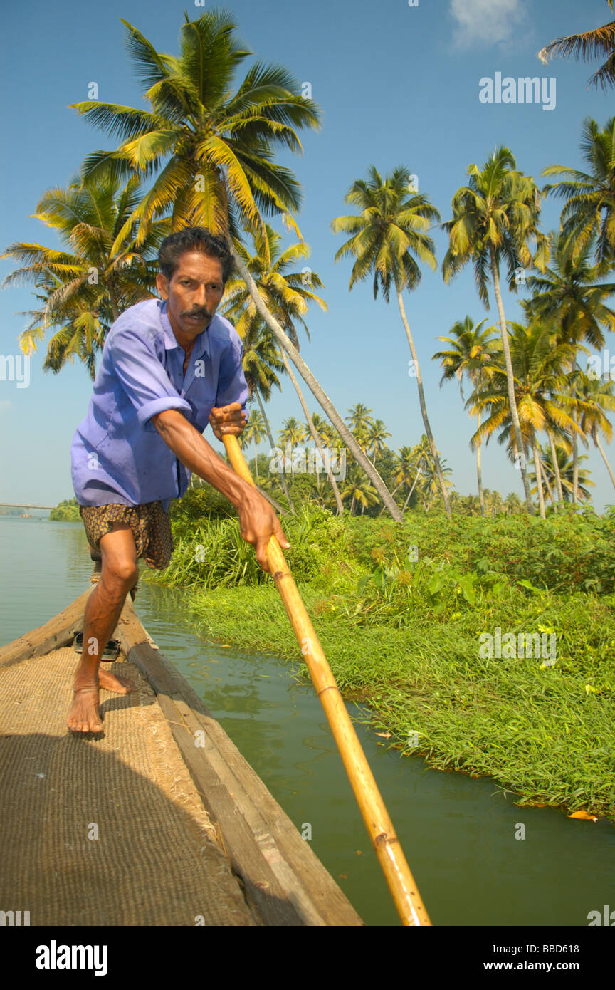 Indian boatman with a punt pole on a boat in the backwaters. Kerala ...