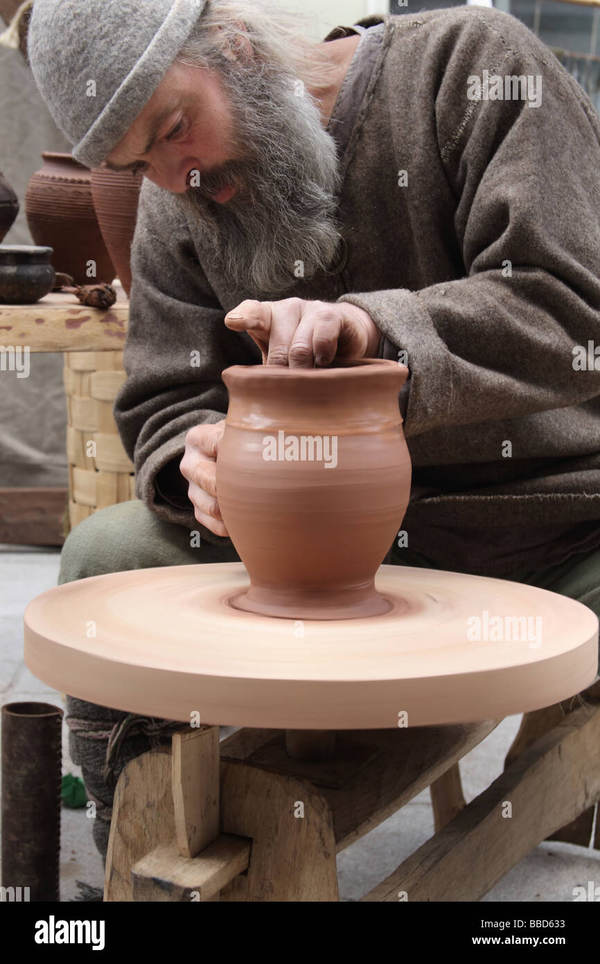 An artist making a clay pot in the traditional method on a potters ...