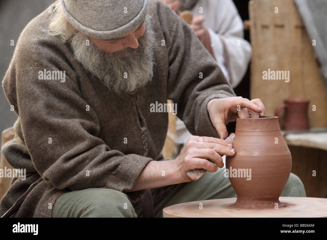 An artist making a clay pot in the traditional method on a potters ...