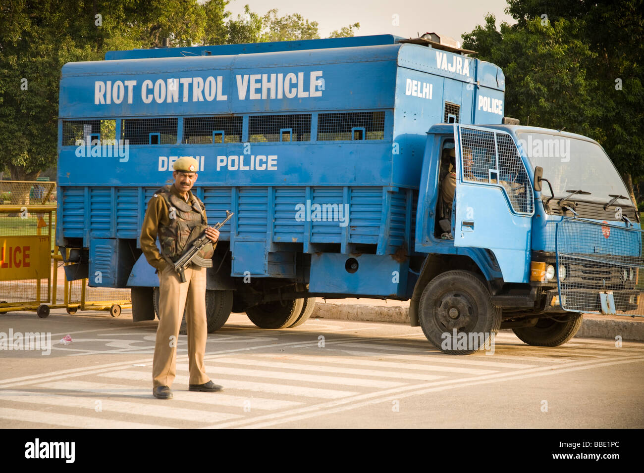 Armed policeman standing beside Delhi Police riot control vehicle ...