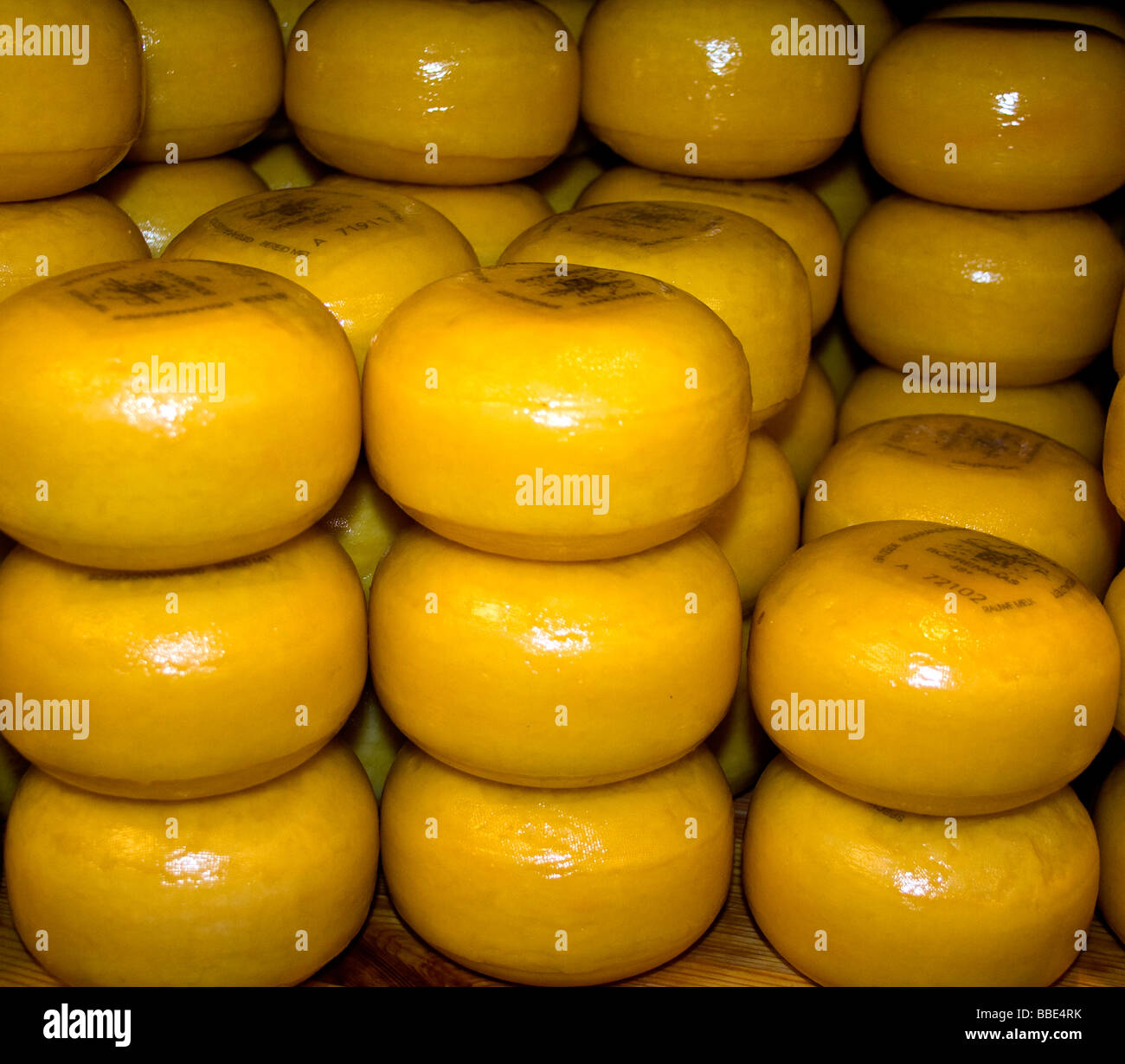 Stacked round Dutch cheeses in yellow wrappings Stock Photo - Alamy