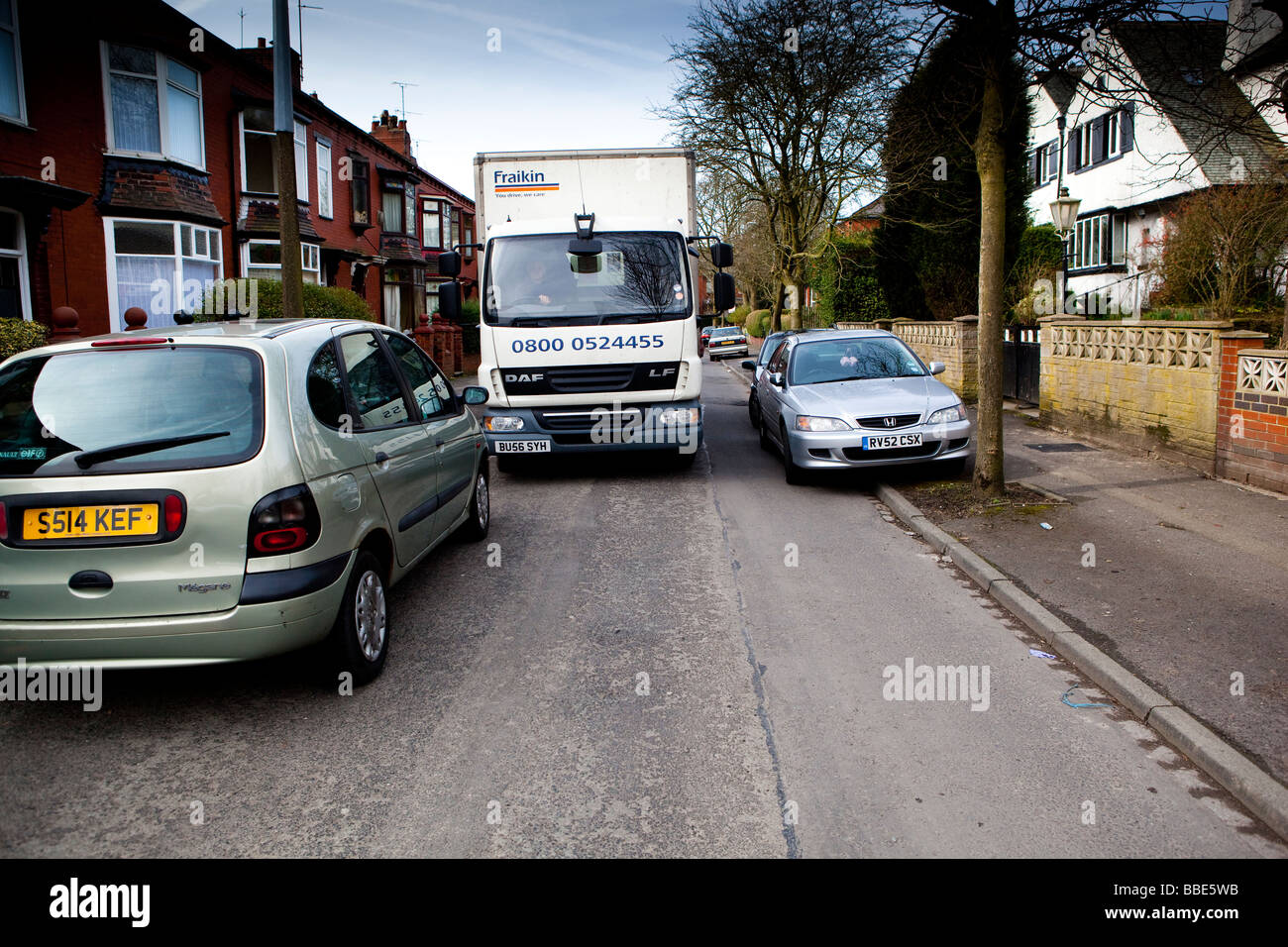 Lorry struggling through a gap between parked cars Stock Photo - Alamy