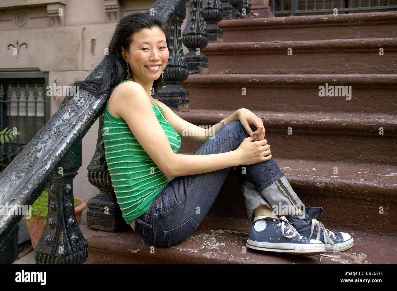 Asian woman sitting on front steps Stock Photo - Alamy