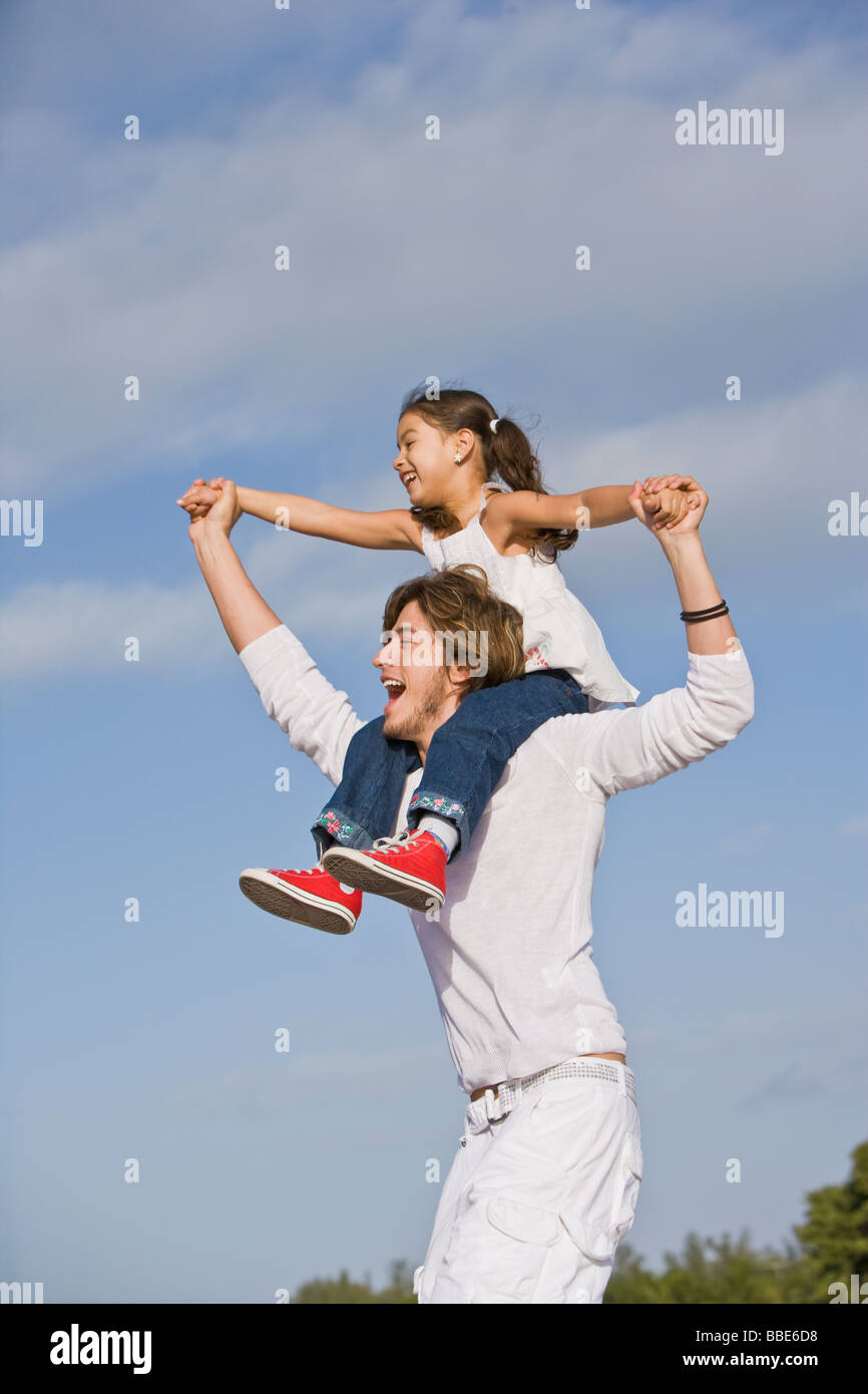 Hispanic father carrying daughter on shoulders Stock Photo - Alamy