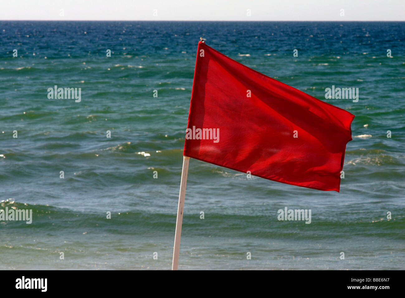 Red Flag flying at Cornish Beach UK Stock Photo - Alamy