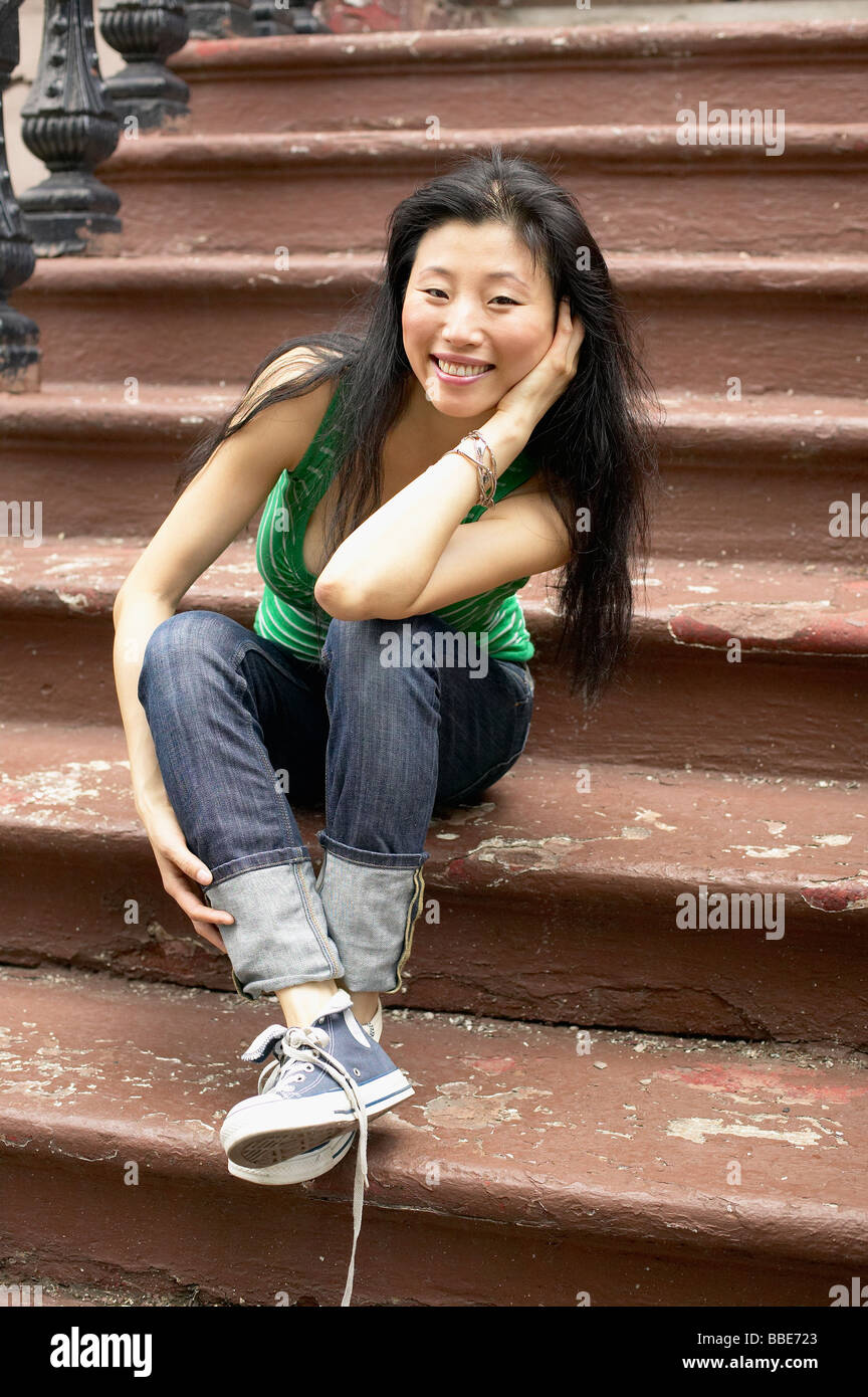 Asian woman sitting on front steps Stock Photo - Alamy