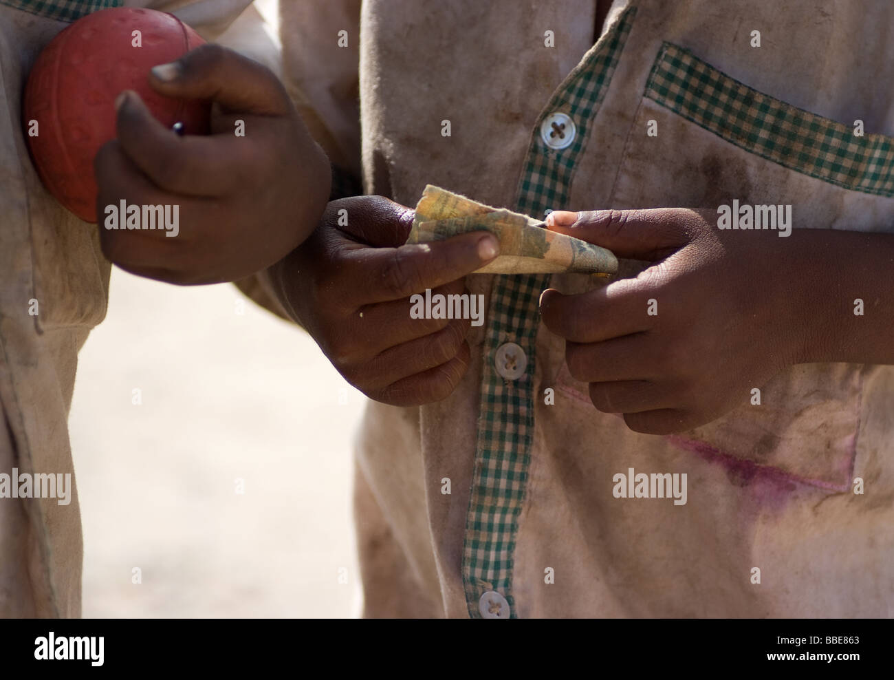 a child shows off money which he received from tourists. whilst the ...