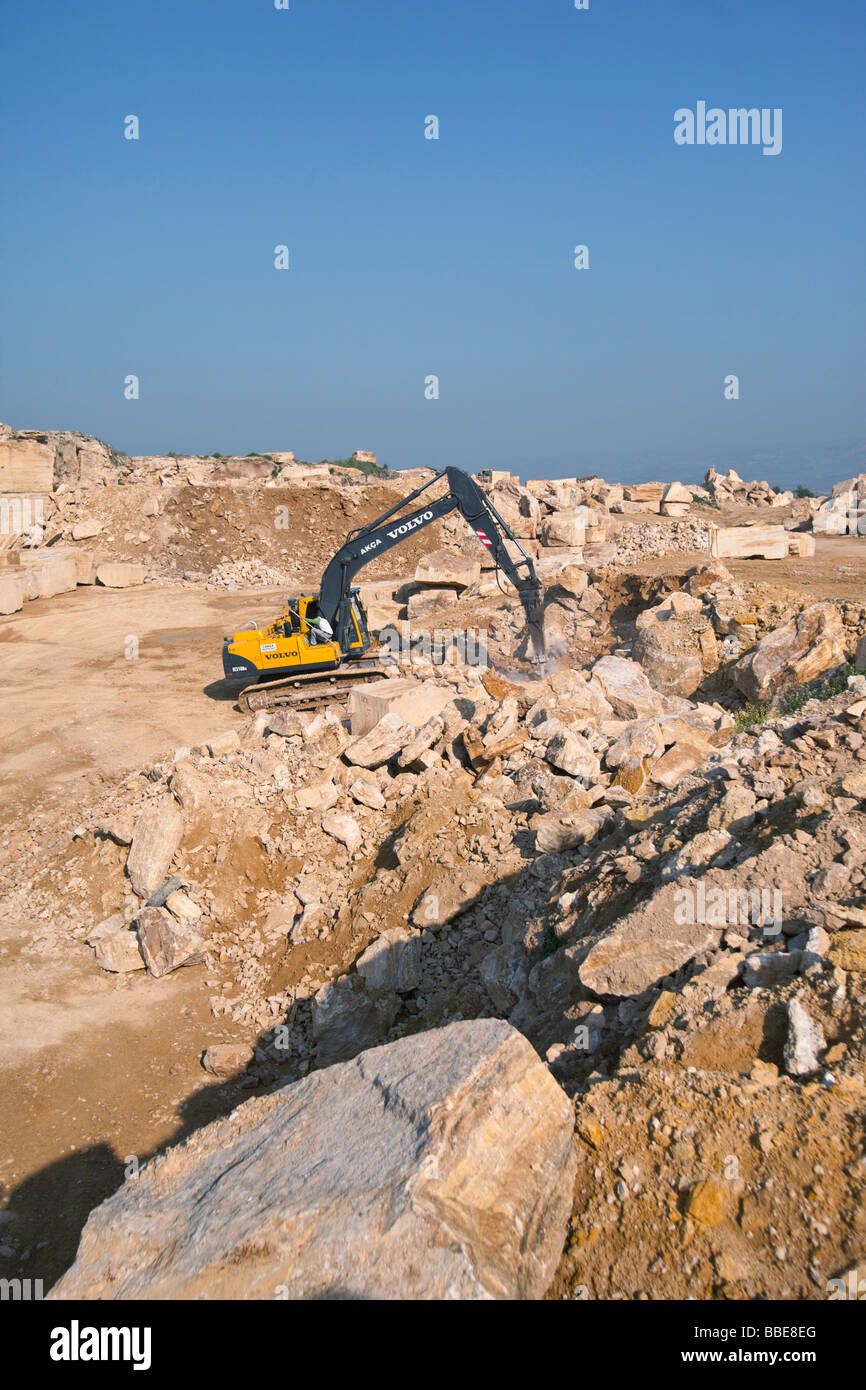 Power hammer chipping blocks of marble from an open pit mine in western ...