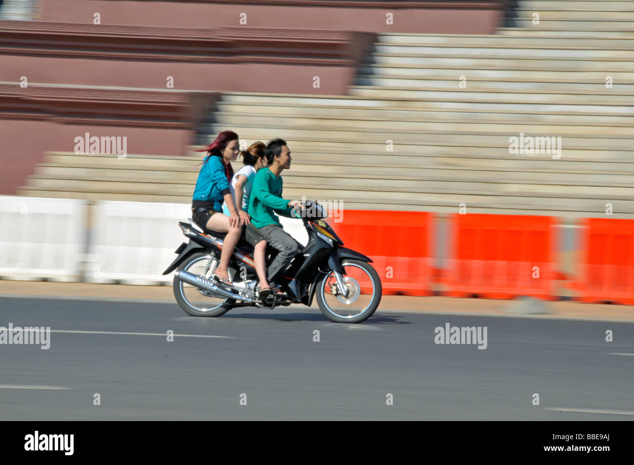 Three Khmer people on a motorbike without wearing helmets, Phnom Penh ...