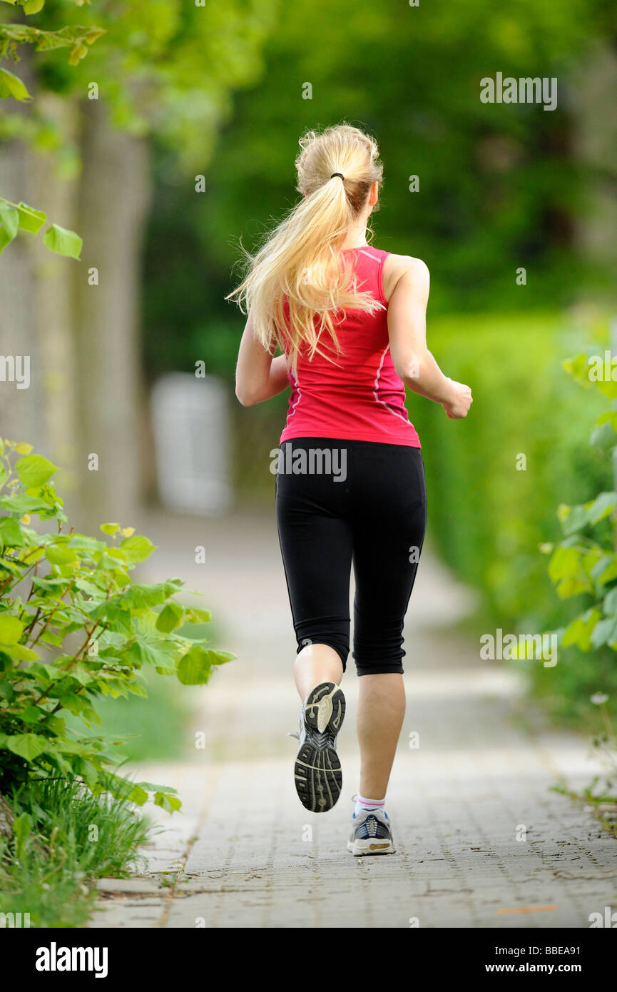 Young woman jogging Stock Photo - Alamy