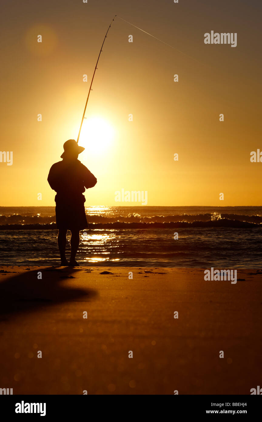Fisherman on beach at sunrise Stock Photo - Alamy