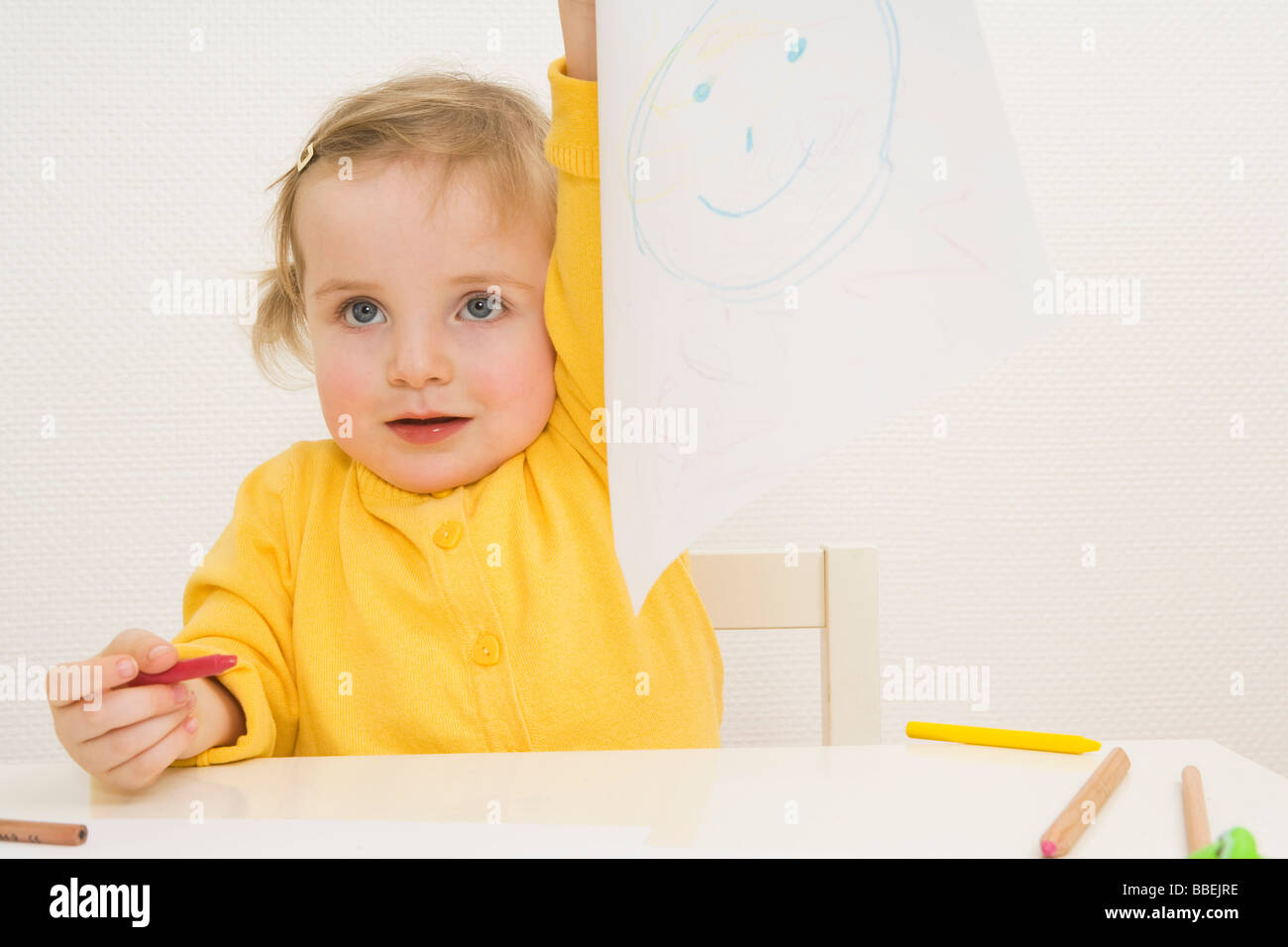 Little Girl Holding Up Her Drawing Stock Photo - Alamy