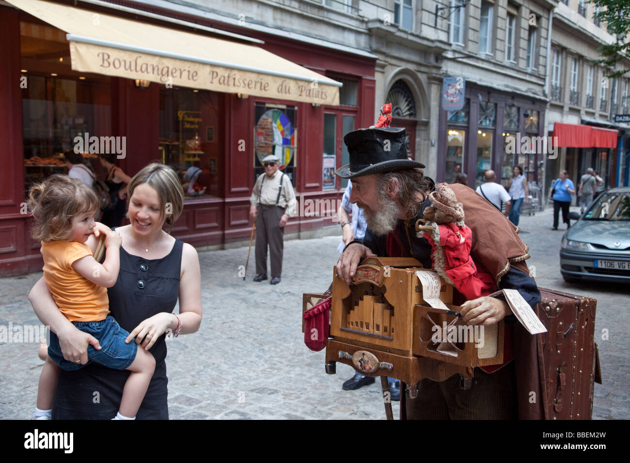 Street artist with hand organ in historic costum with Vieux Lyon Old ...